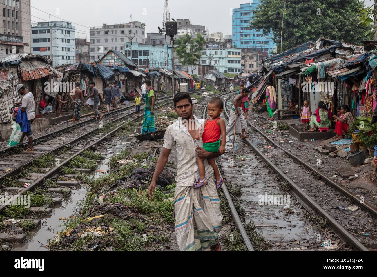 Father with his son walking on the railway tracks, Tejgaon Slum Area ...