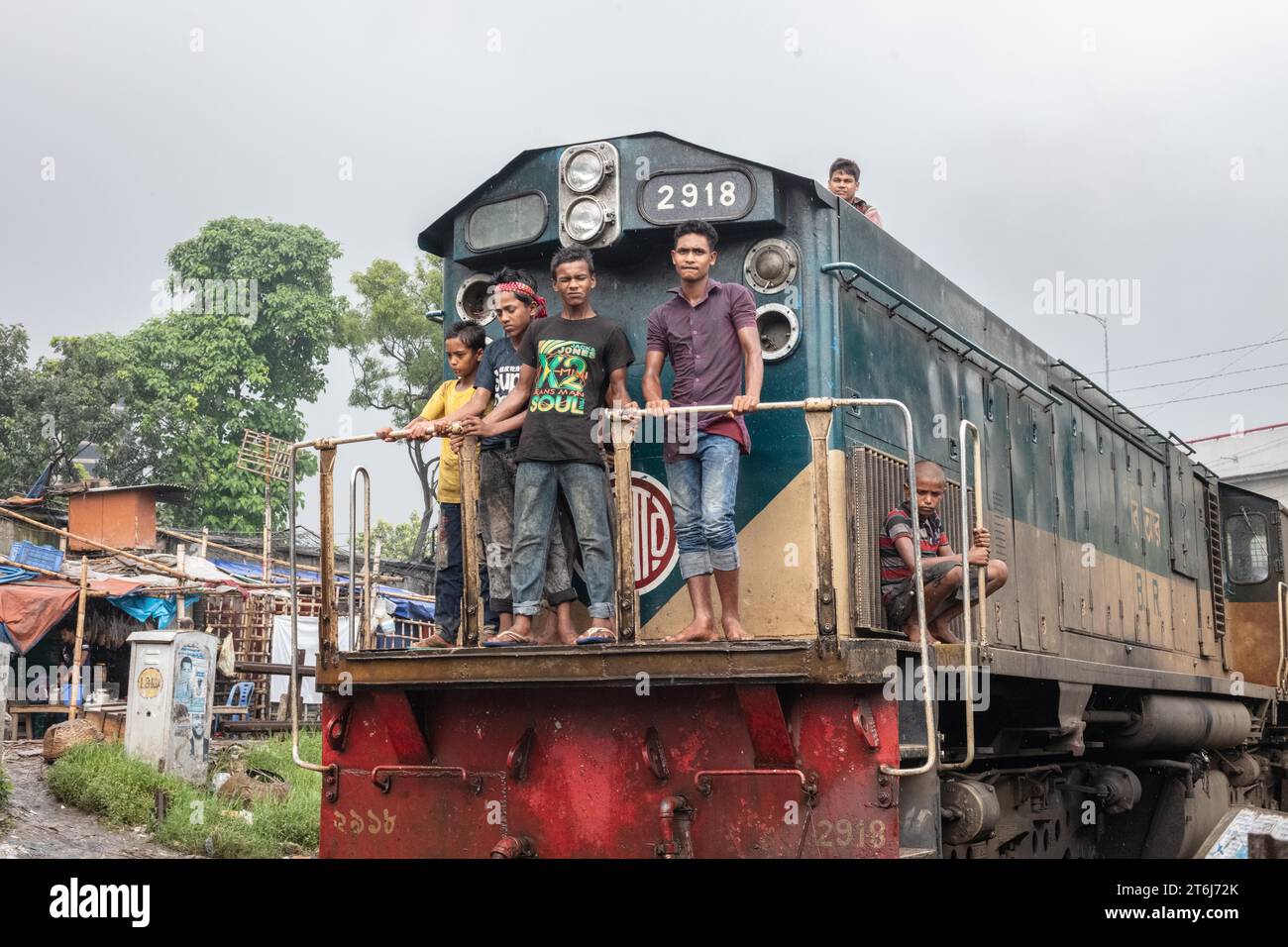 Children on the locomotive of a train travelling through the Tejgaon ...