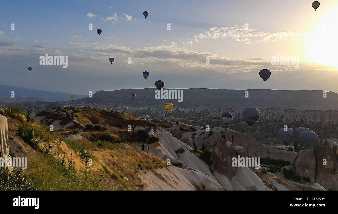 Hot air balloon flying over rock landscape at Cappadocia Turkey. Cave ...