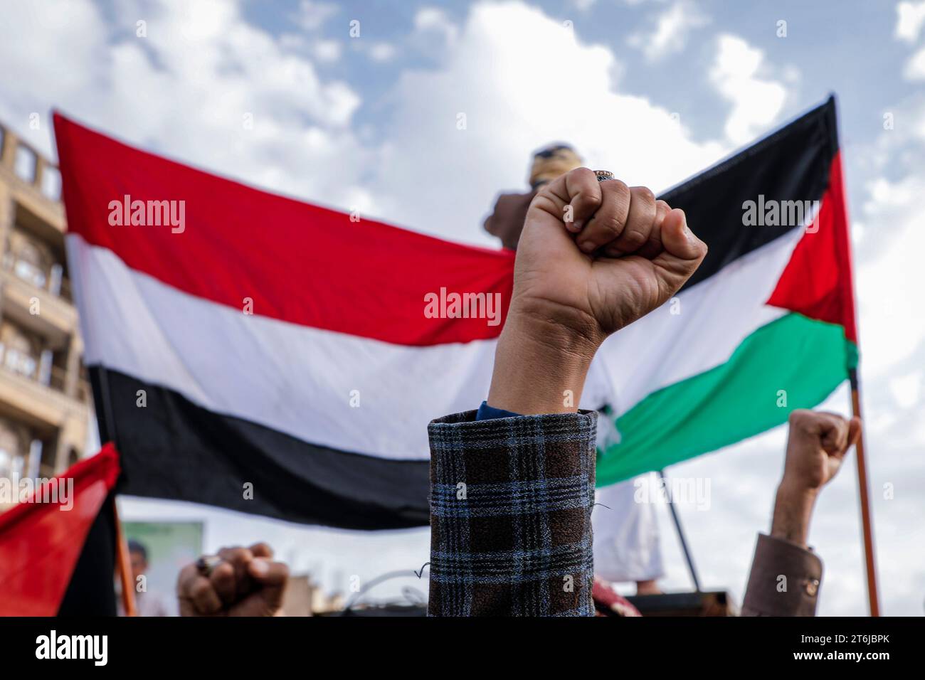 10 November 2023, Yemen, Sana'a: Men chant slogans and wave flags ...
