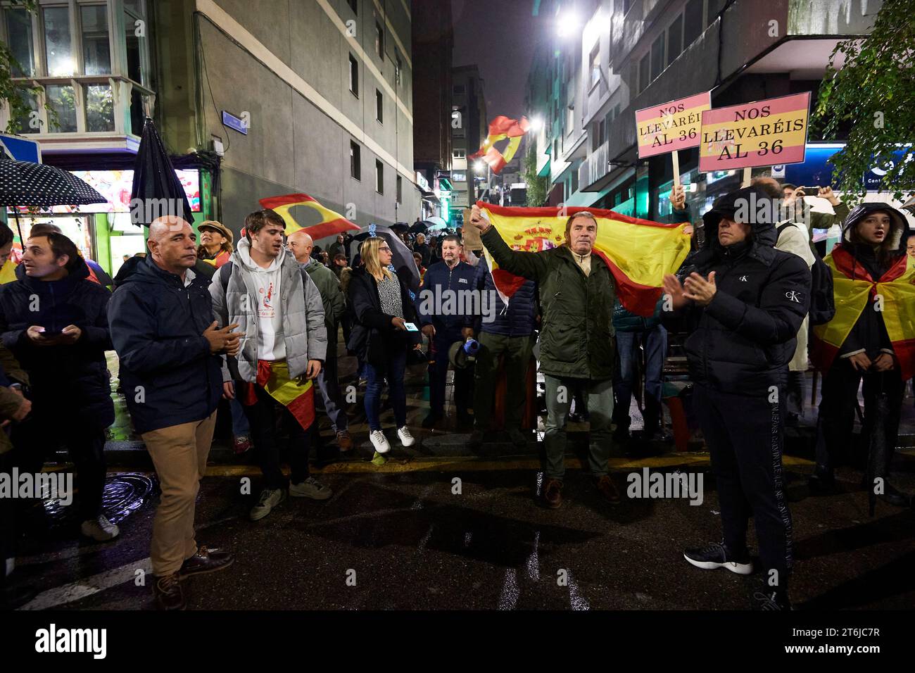 Dozens of people carry flags, umbrellas and posters, during a rally ...