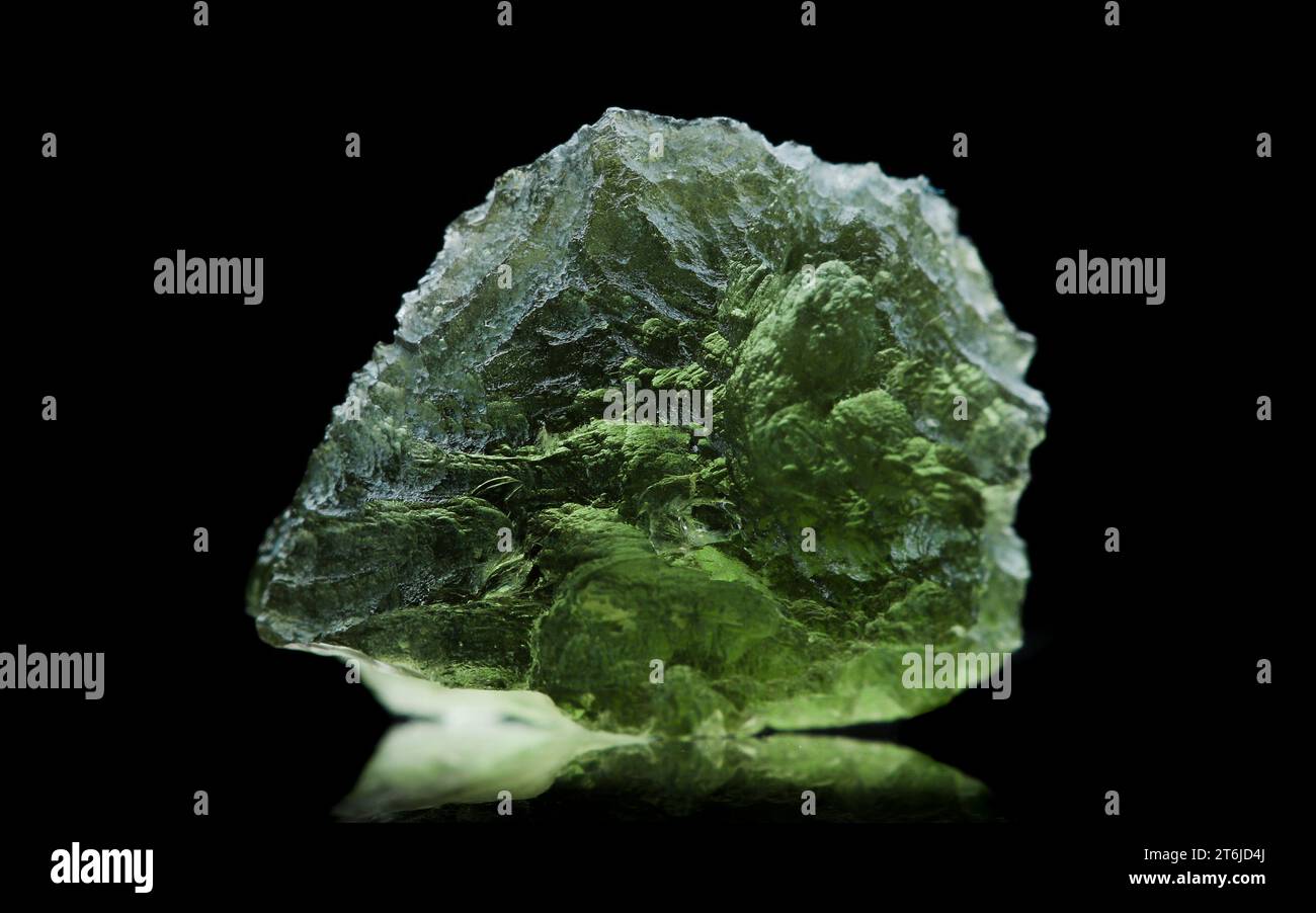 Moldavite stone isolated on black background. Close up of a green ...