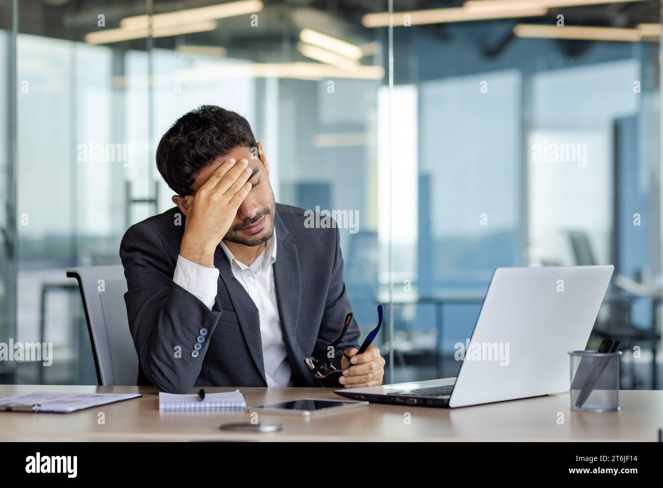 Overtired and overwhelmed businessman at workplace inside office, man ...