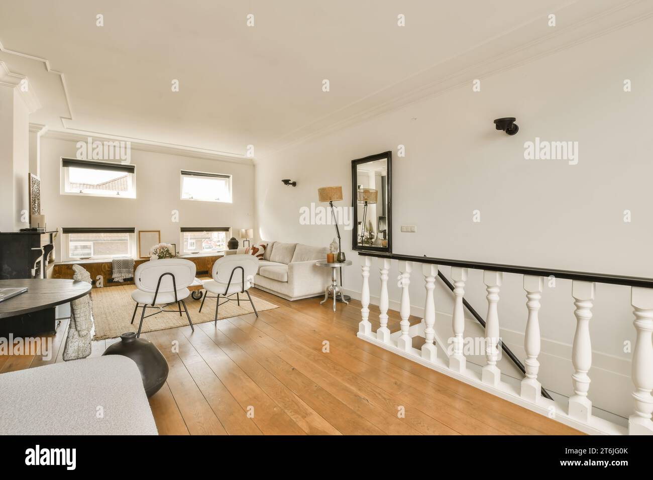 a living room with white walls and hardwood flooring, including a ...