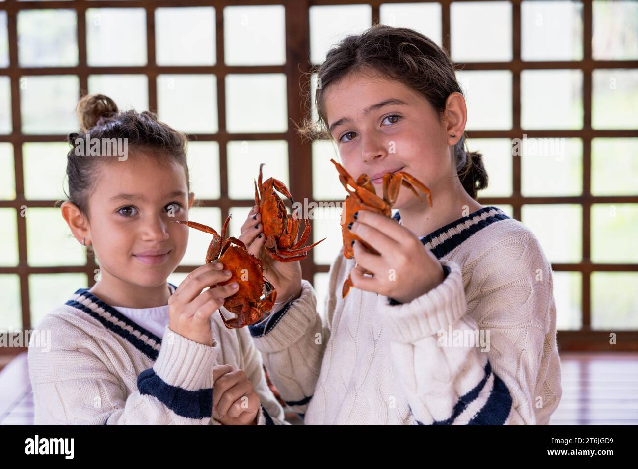 Two girls posing with shellfish in their hands to examine them and know ...