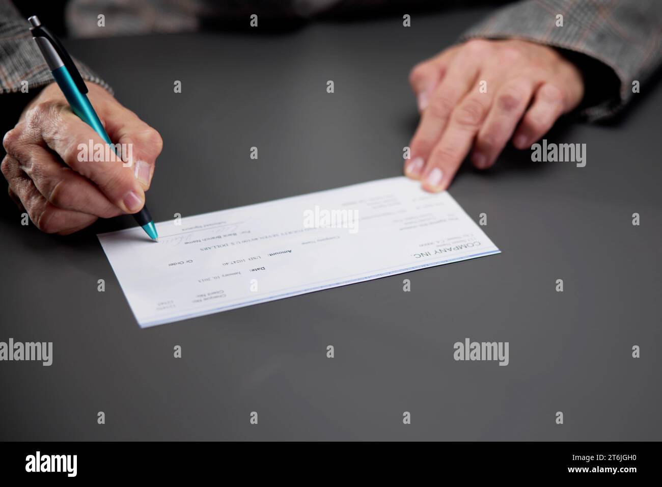 Confident Woman Writing Bank Cheque with Signature Stock Photo - Alamy