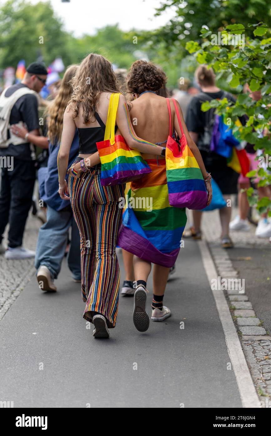 A vertical shot of two people wearing colorful rainbow clothing ...