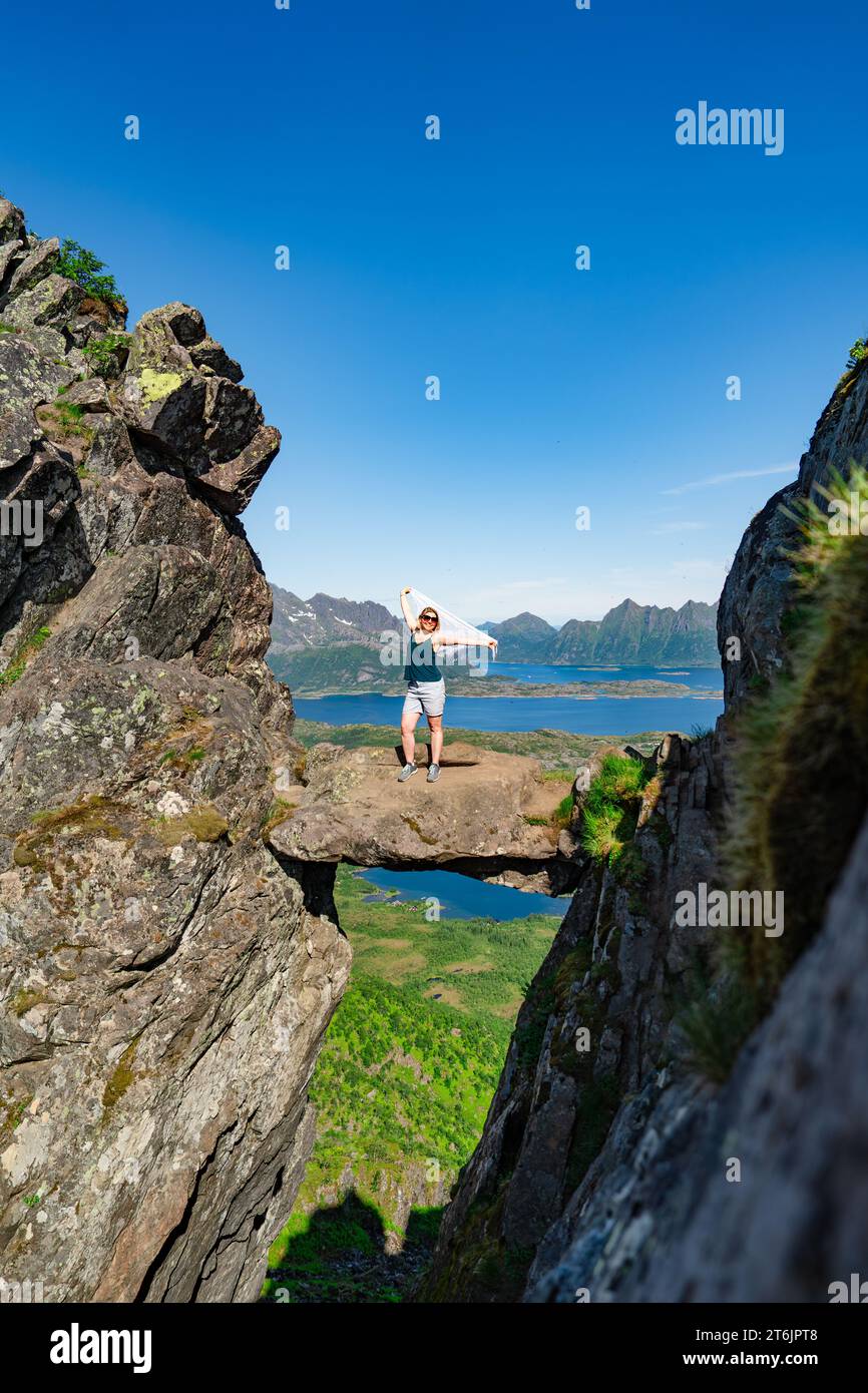 Brave traveler woman standing on hanging stone between rocks ...