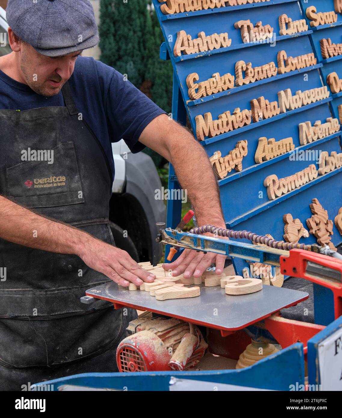 Local craftsman jigsawing people names from wood Stock Photo - Alamy