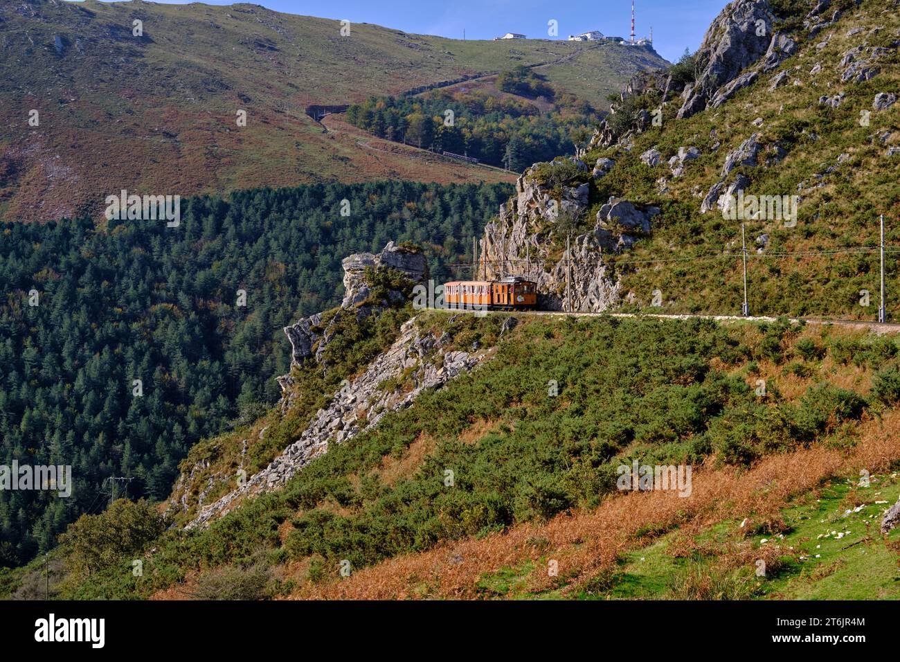Small funicular railway train of La Rhune passes a tight cleft in ...