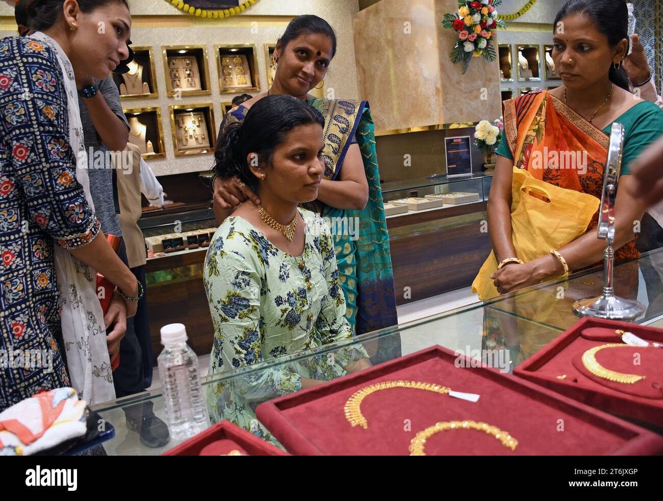 A woman tries a gold necklace at Senco Gold and Diamonds store on the occasion of Dhanteras in ...