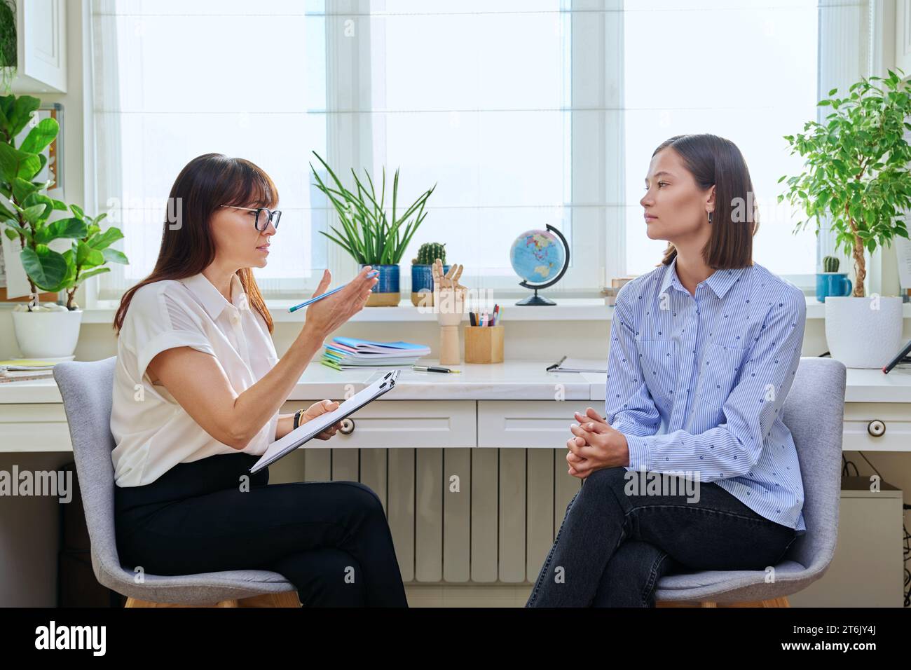 Female psychologist working with young woman in office Stock Photo - Alamy