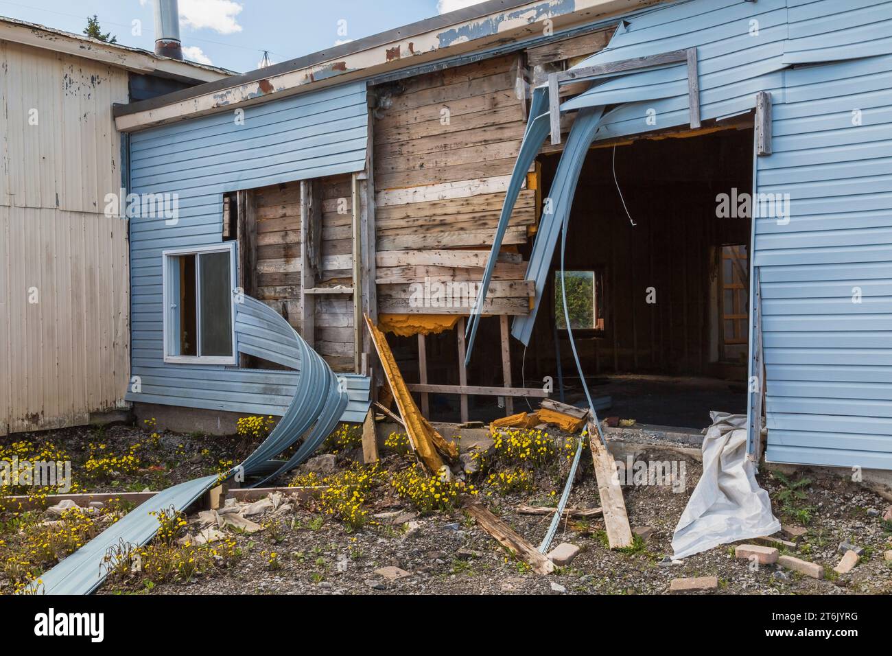 Partially demolished blue vinyl cladded building Stock Photo - Alamy