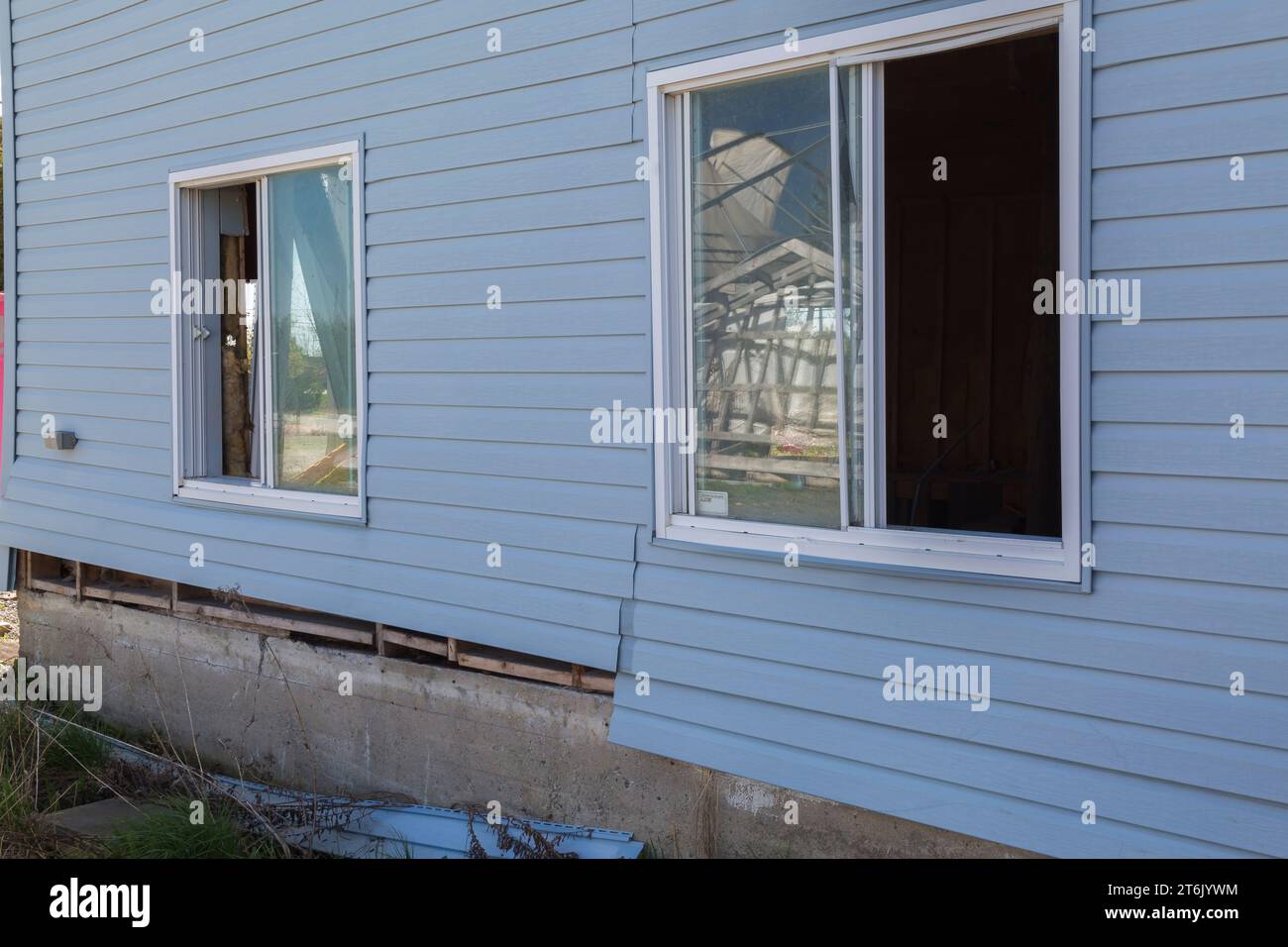 Partially demolished blue vinyl cladded building Stock Photo - Alamy