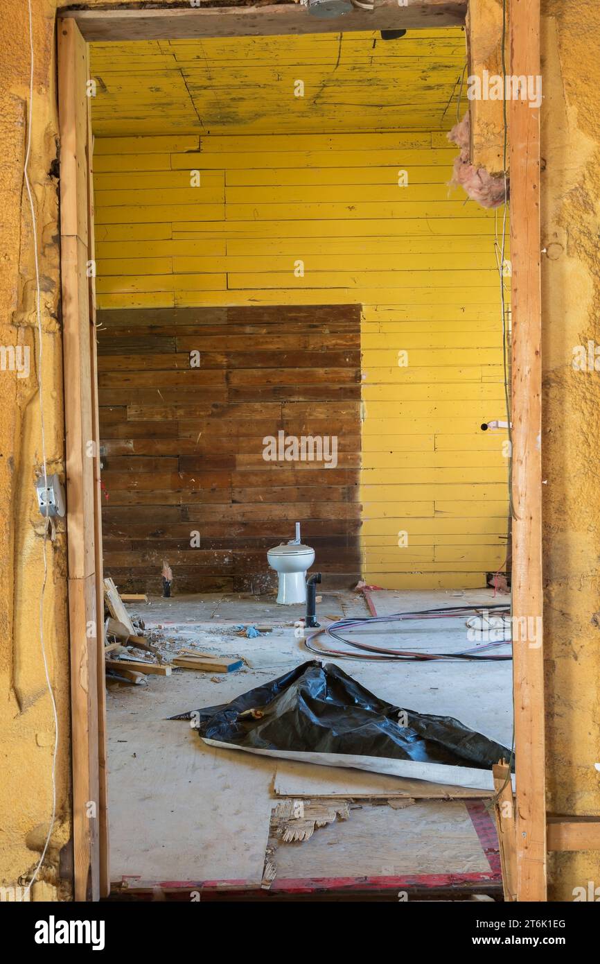 Old toilet with water tank removed and debris in abandoned commercial ...