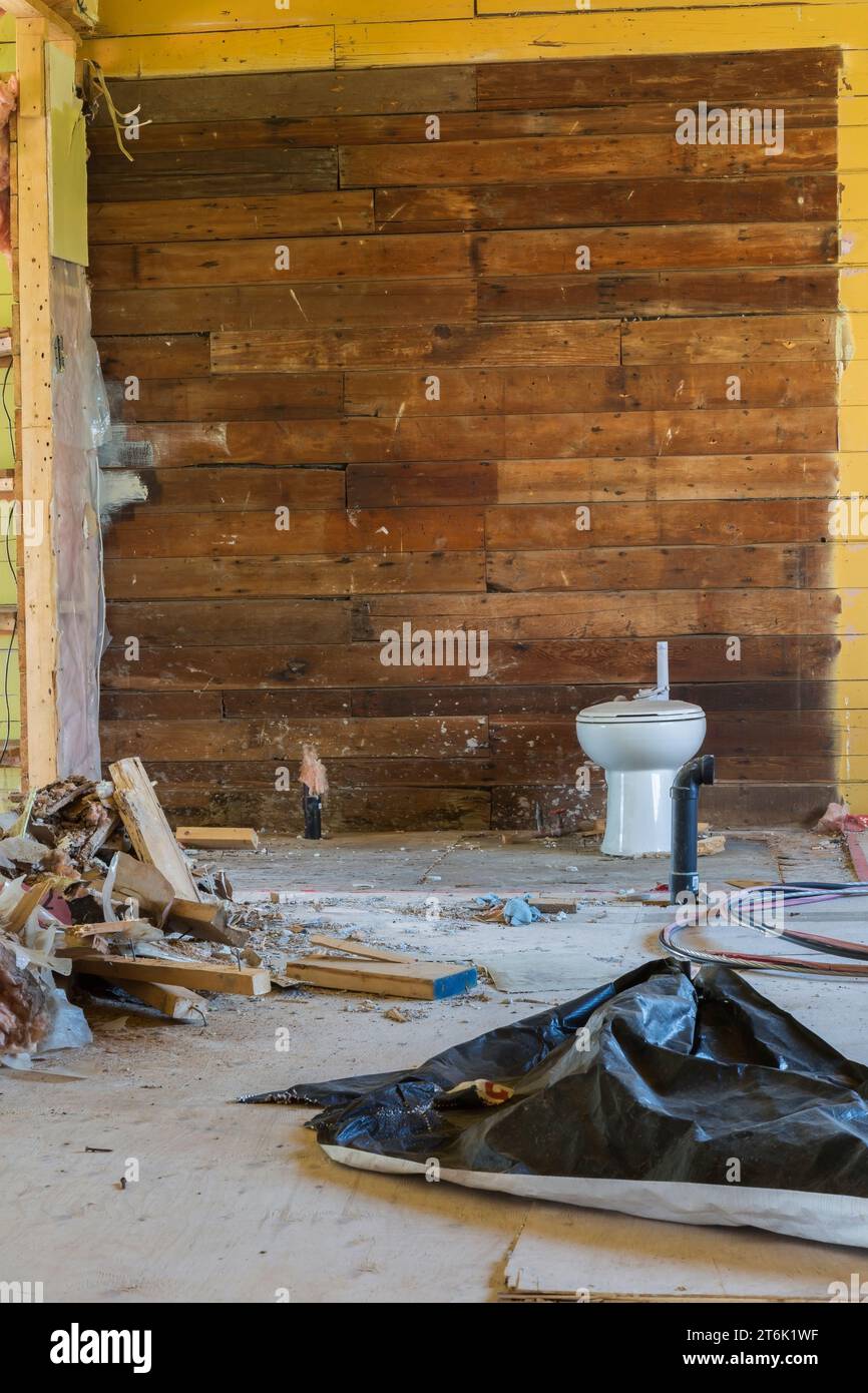 Old toilet with water tank removed and debris in abandoned commercial ...