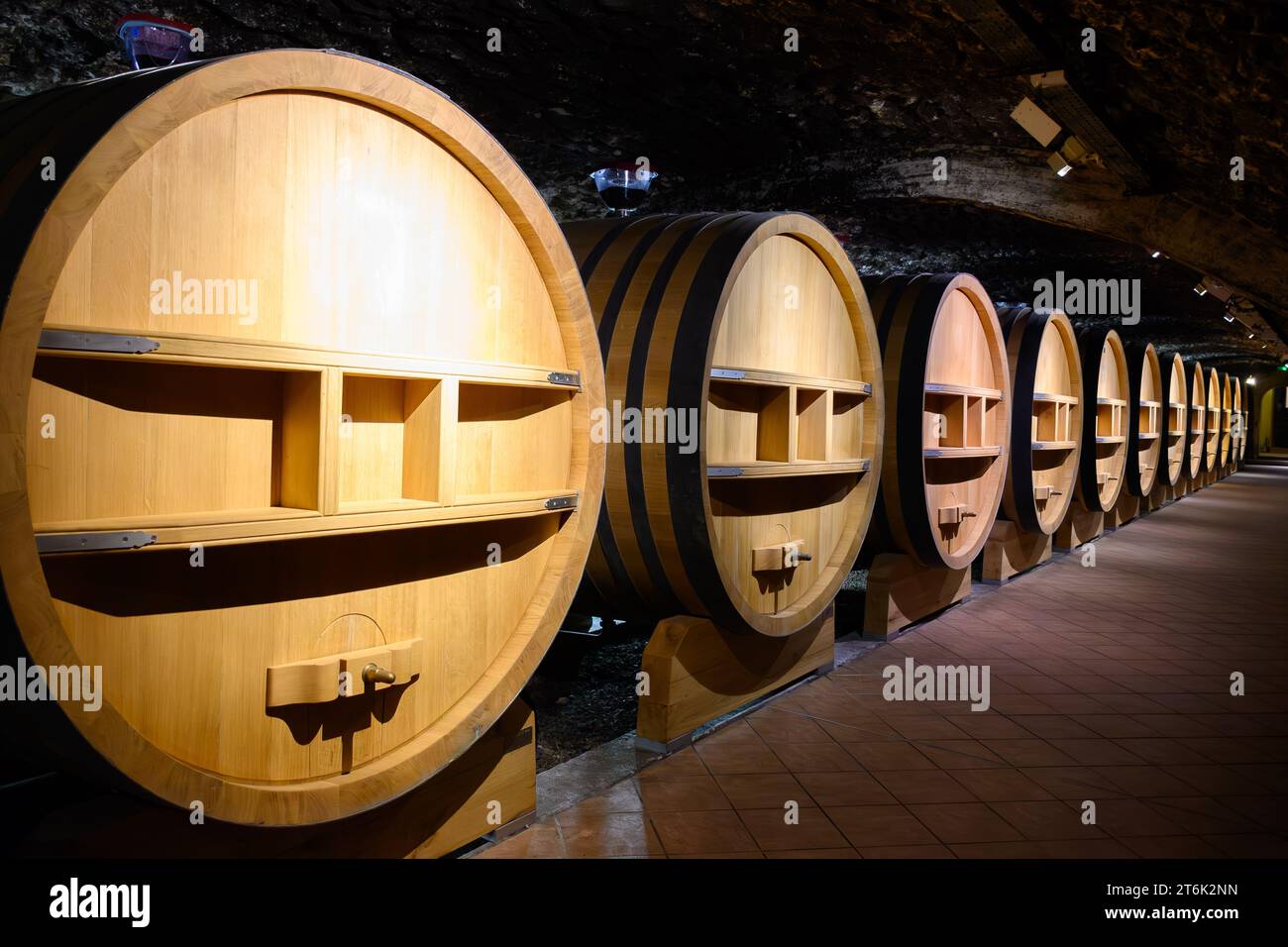 Underground wine cellars with barrels for aging of red dry wine in Chateauneuf-du-Pape wine ...