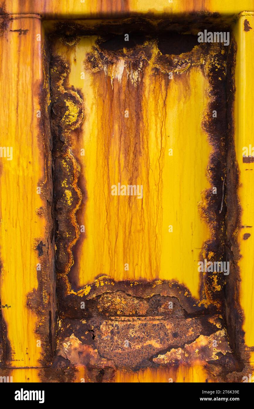 Rust spots and stains on side wall of old yellow metal waste container ...