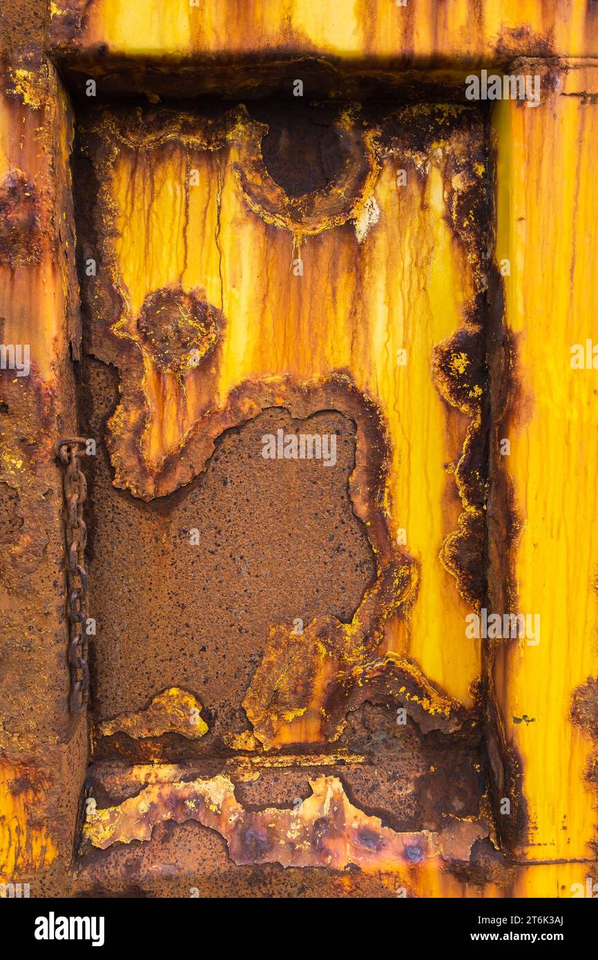 Rust spots and stains on side wall of old yellow metal waste container ...