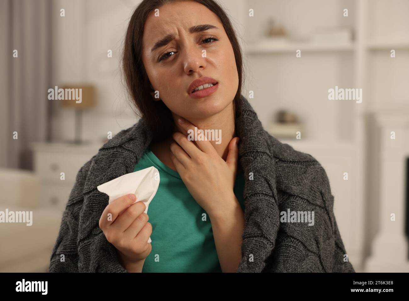 Sick woman wrapped in blanket with tissue at home. Cold symptoms Stock Photo - Alamy
