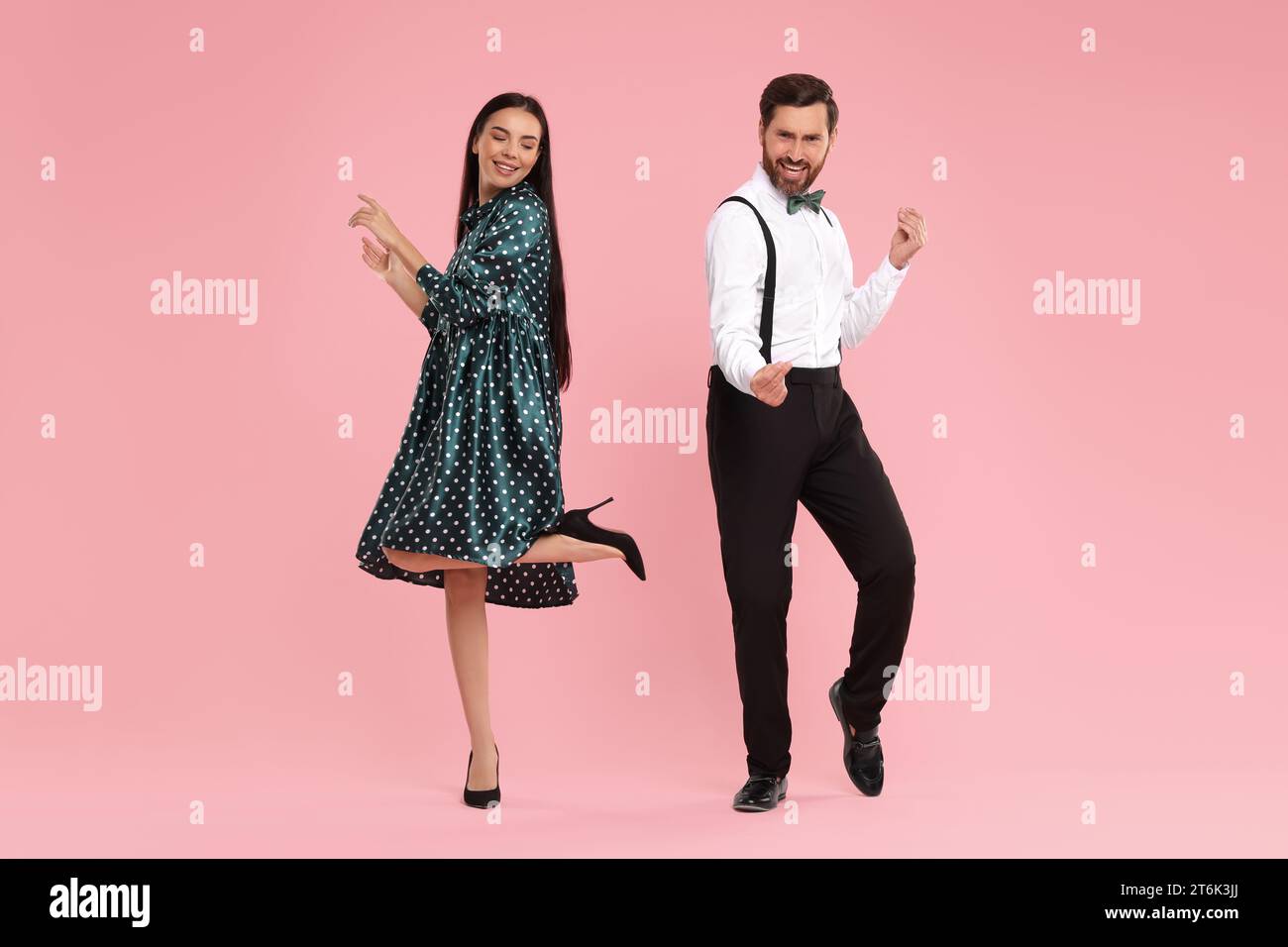 Happy couple dancing together on pink background Stock Photo - Alamy