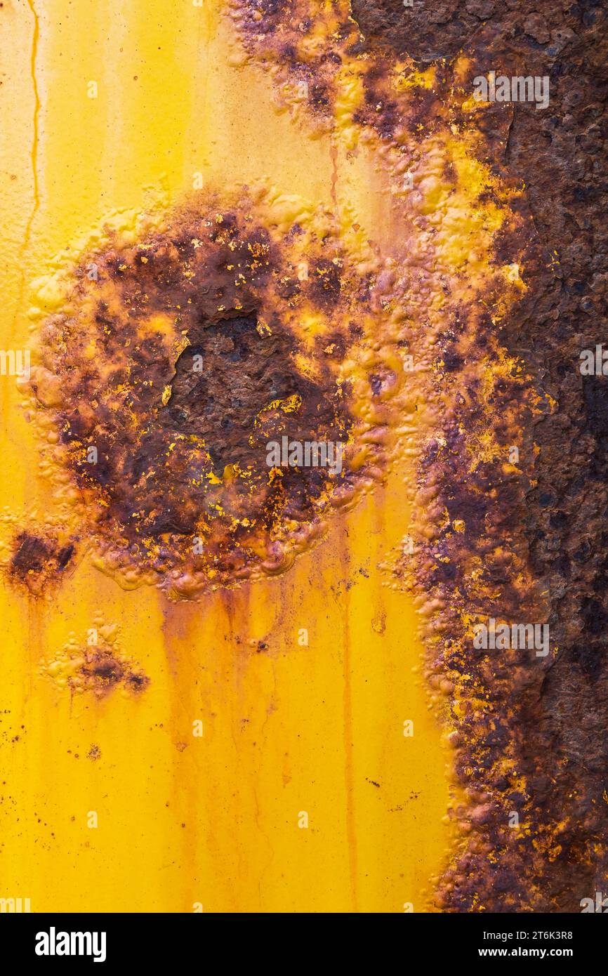 Rust spots and stains on side wall of old yellow metal waste container ...
