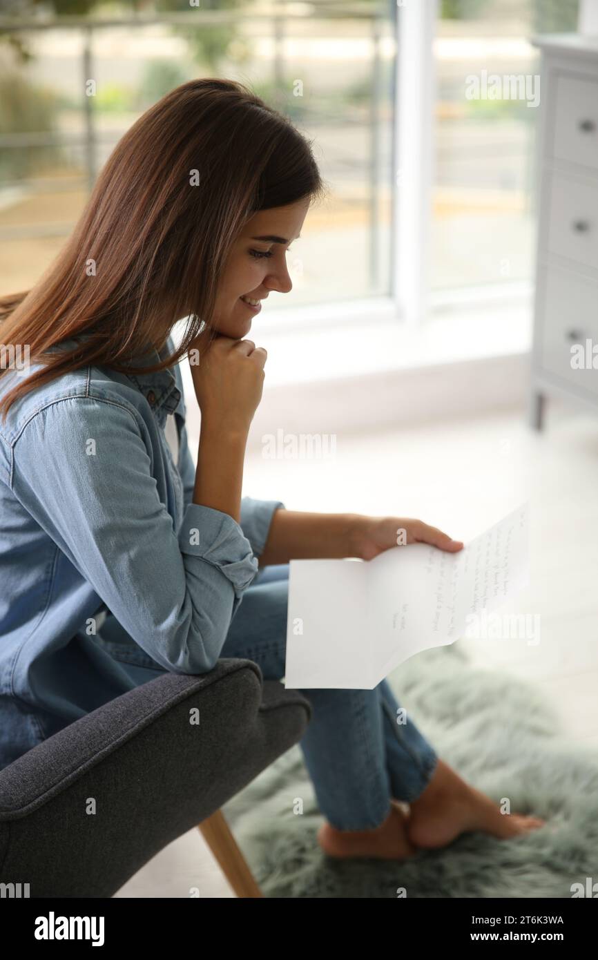 Young woman reading paper letter at home Stock Photo - Alamy
