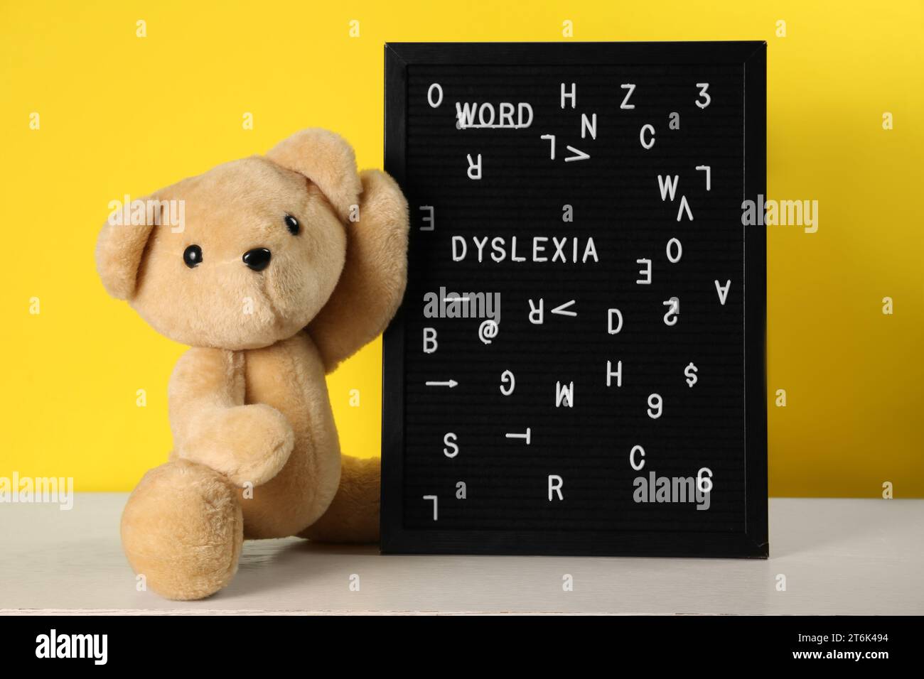 Black letter board with word Dyslexia and teddy bear on light table ...