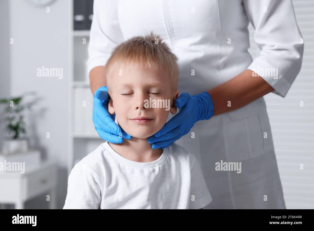 Endocrinologist examining boy's thyroid gland at hospital, closeup ...