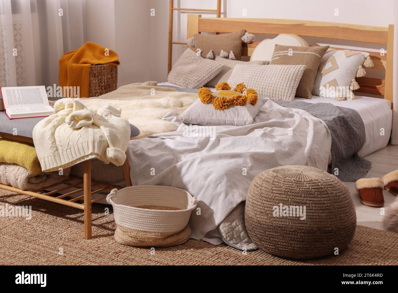 Large comfortable bed with soft pillows, blankets, clothes and slippers ...