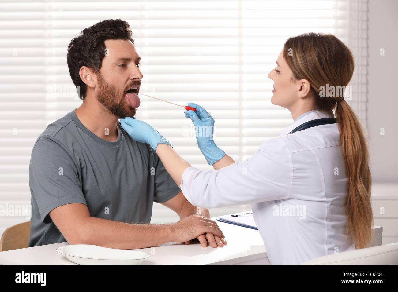 Doctor taking throat swab sample from man`s oral cavity indoors Stock ...