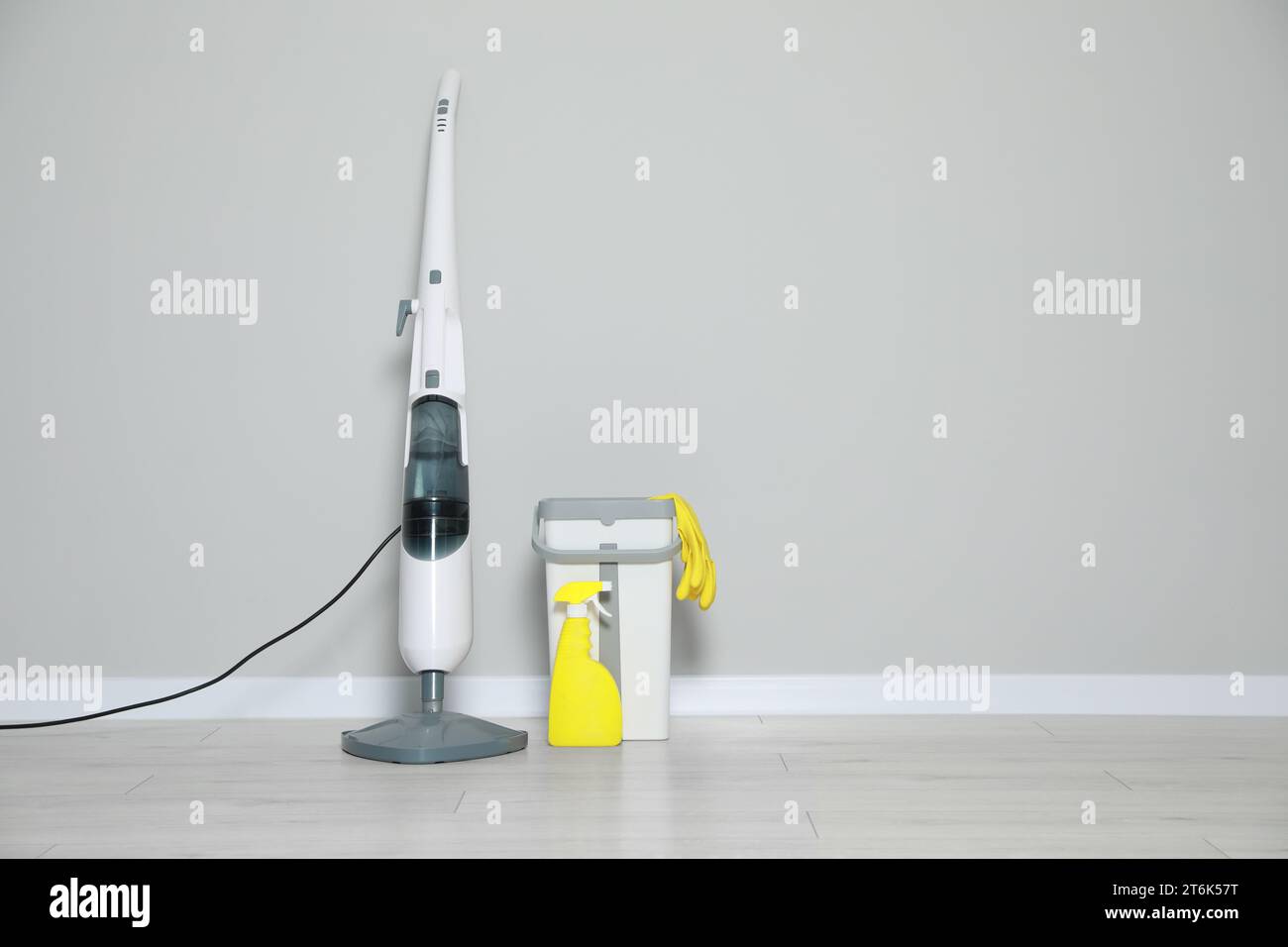 Modern steam mop, bucket with gloves and spray of cleaning product on ...
