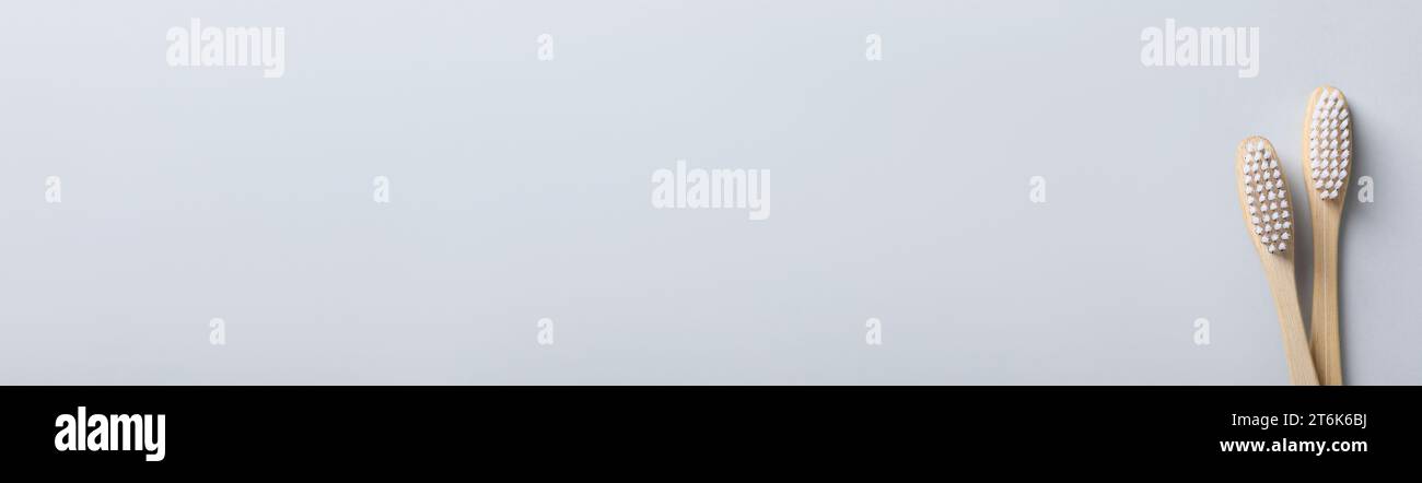 Bamboo toothbrushes on white background, top view. Banner design with ...
