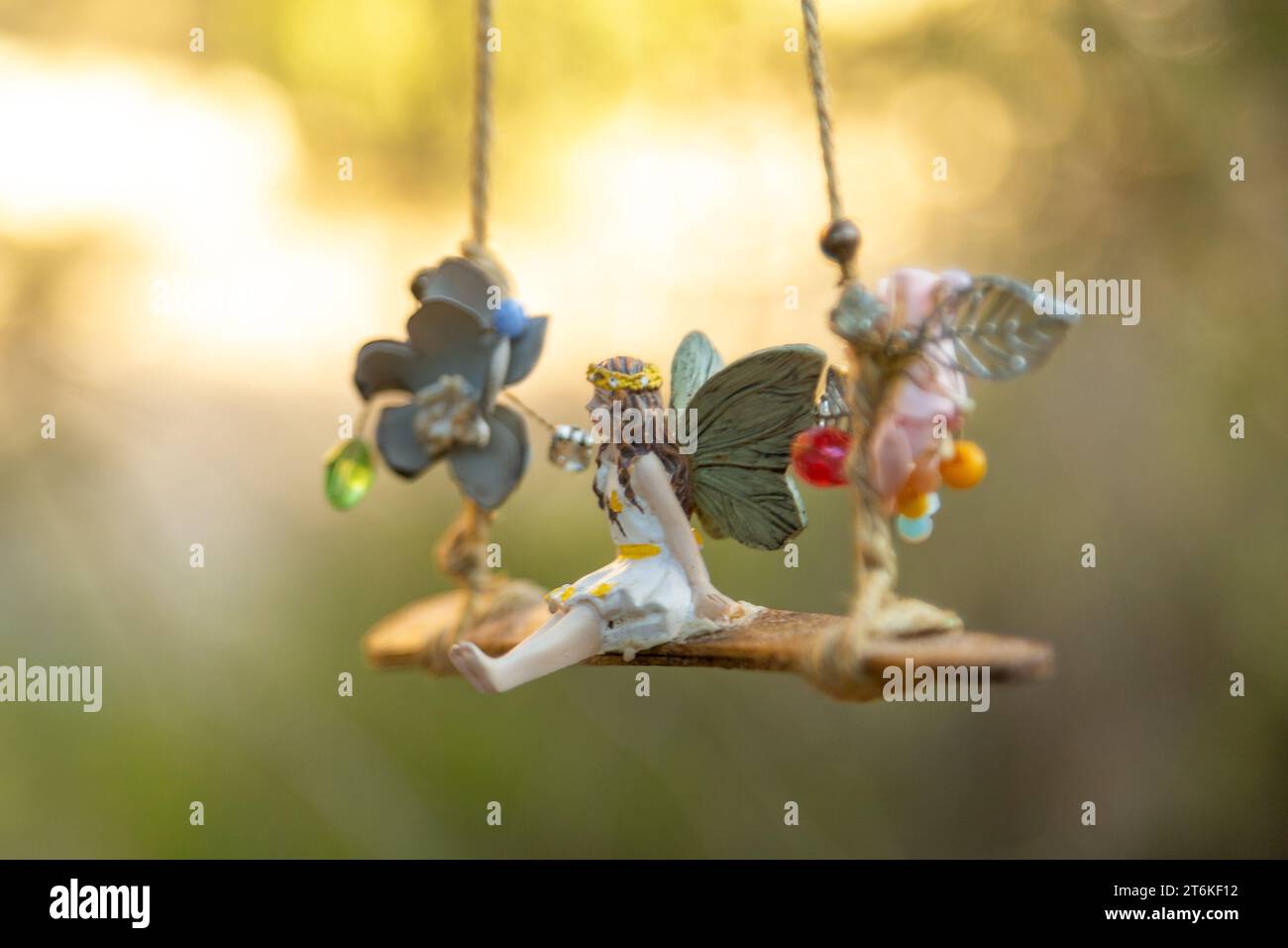 Forest fairy figure on a swing with out of focus background. magical ...