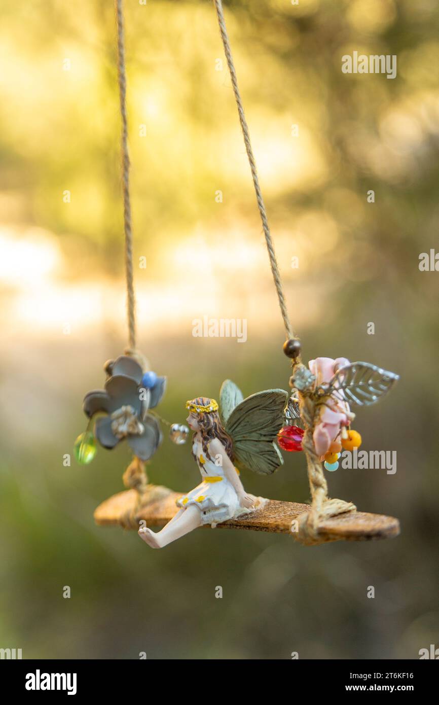 Forest fairy figure on a swing with out of focus background. magical ...