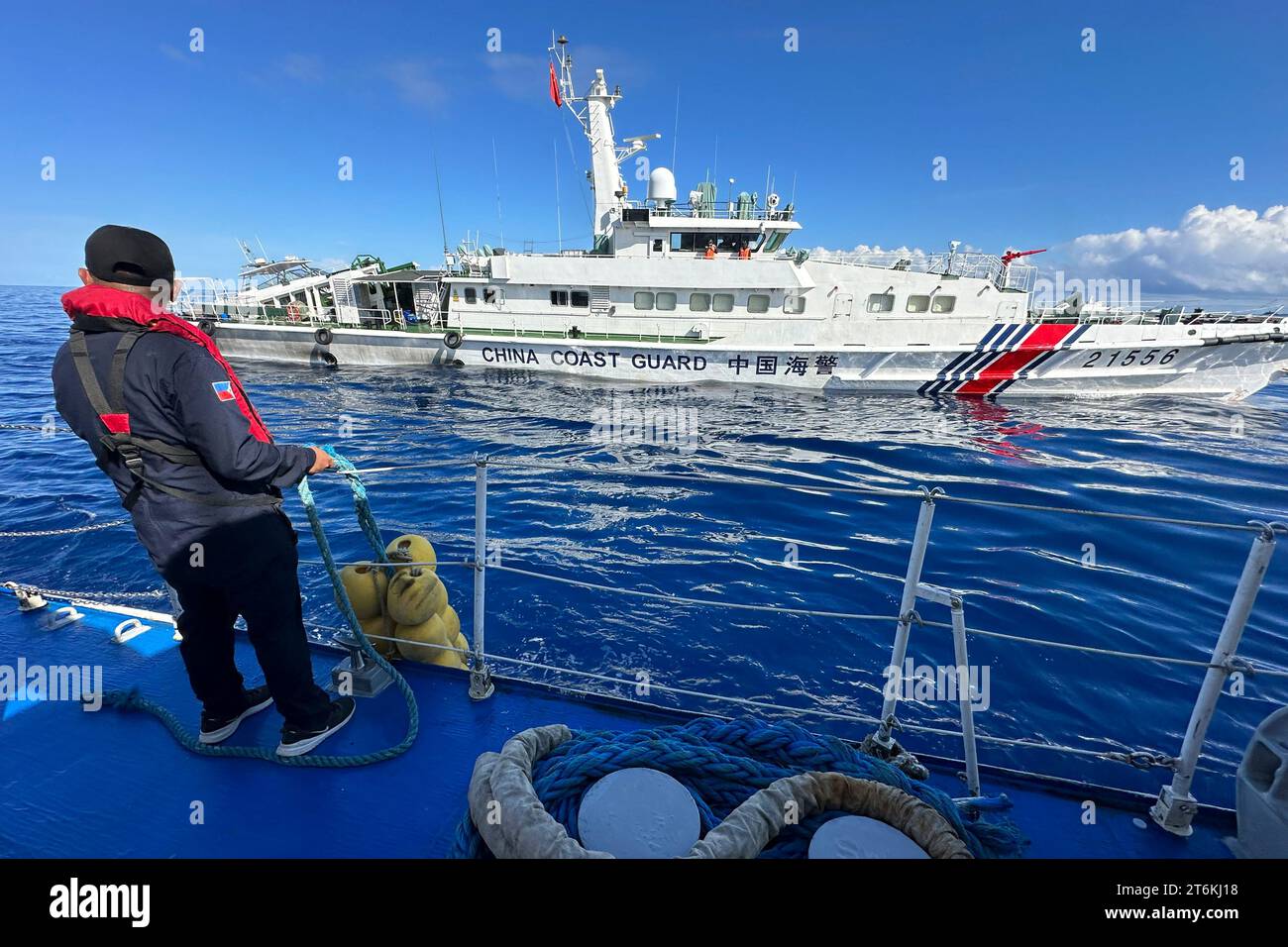 A Philippine Coast Guard Member Holds On A Rubber Fender As A Chinese