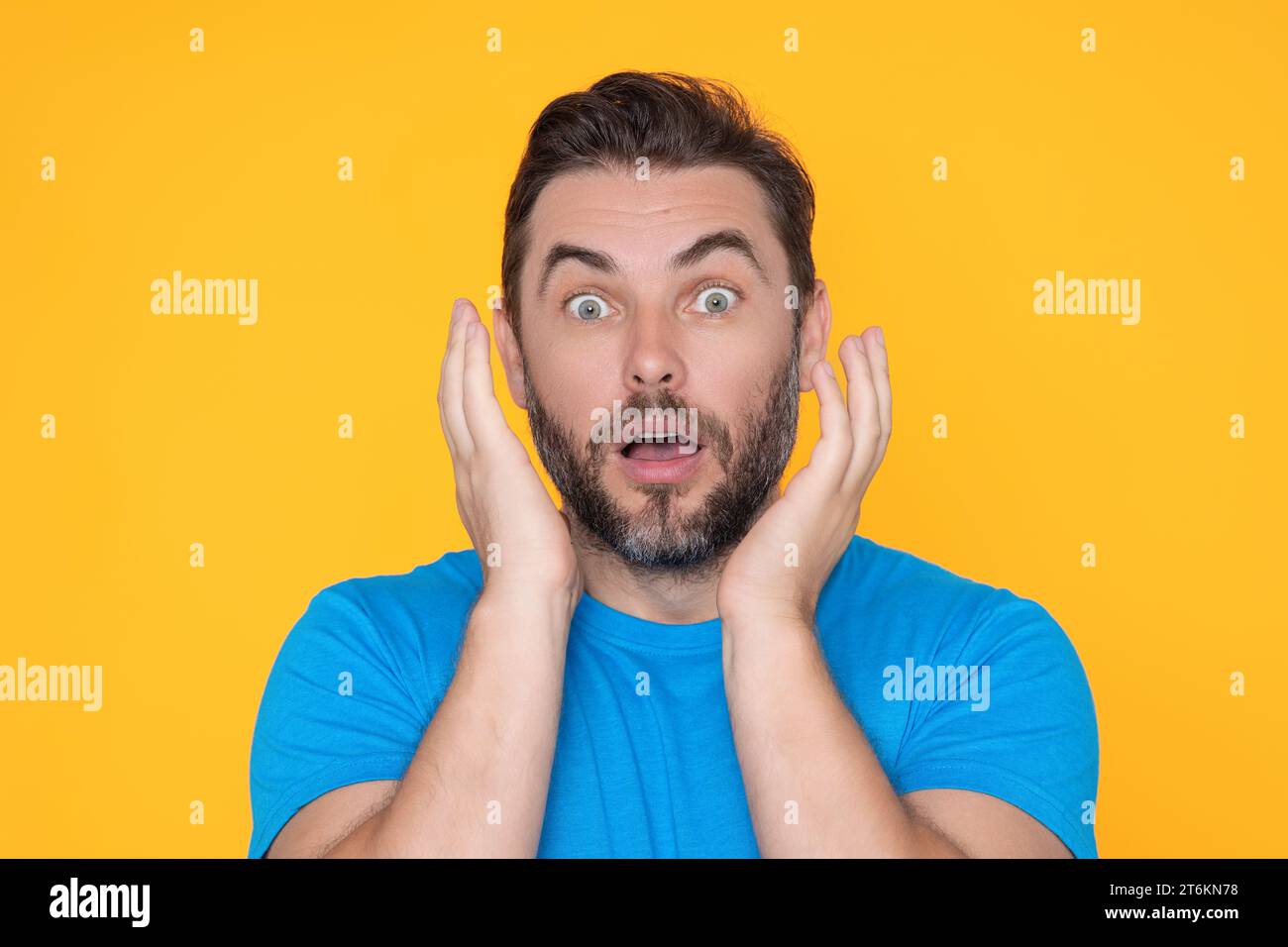 Studio portrait of a man shocked. Surprised man in blue t-shirt ...