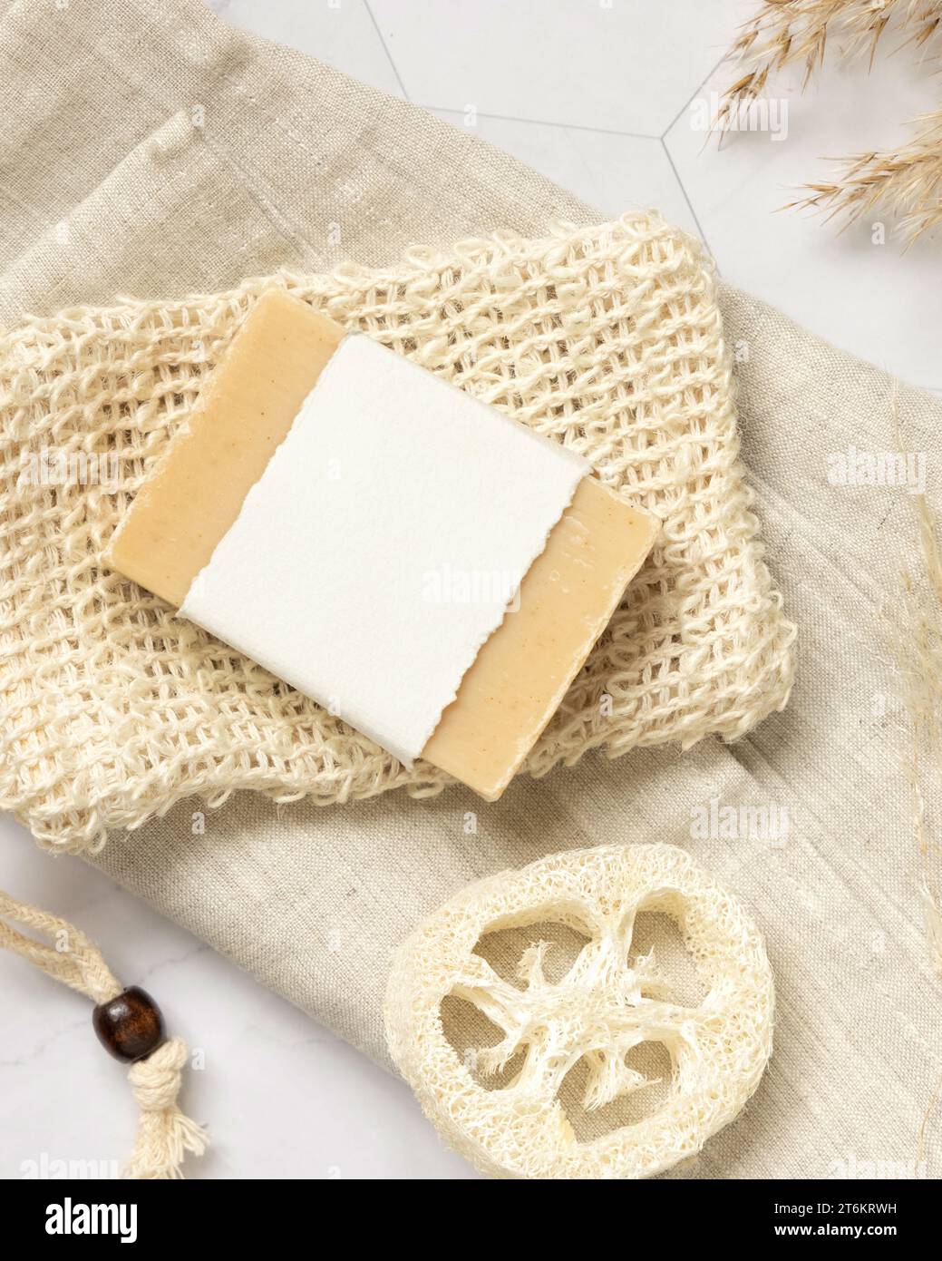 Beige soap bar with blank label on soap saver bag near natural sponge ...