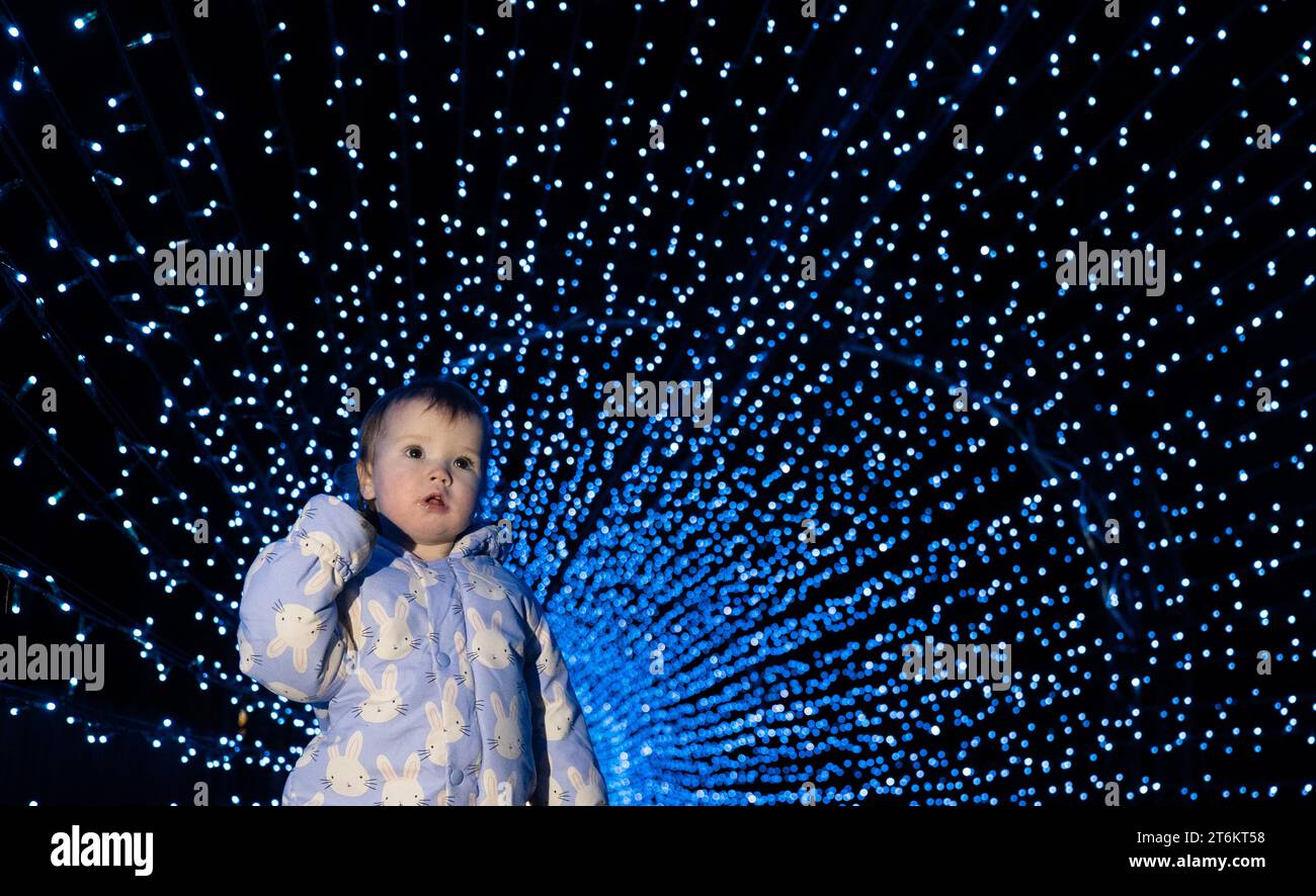 One-year-old Summer enjoys walking through a light installation during ...