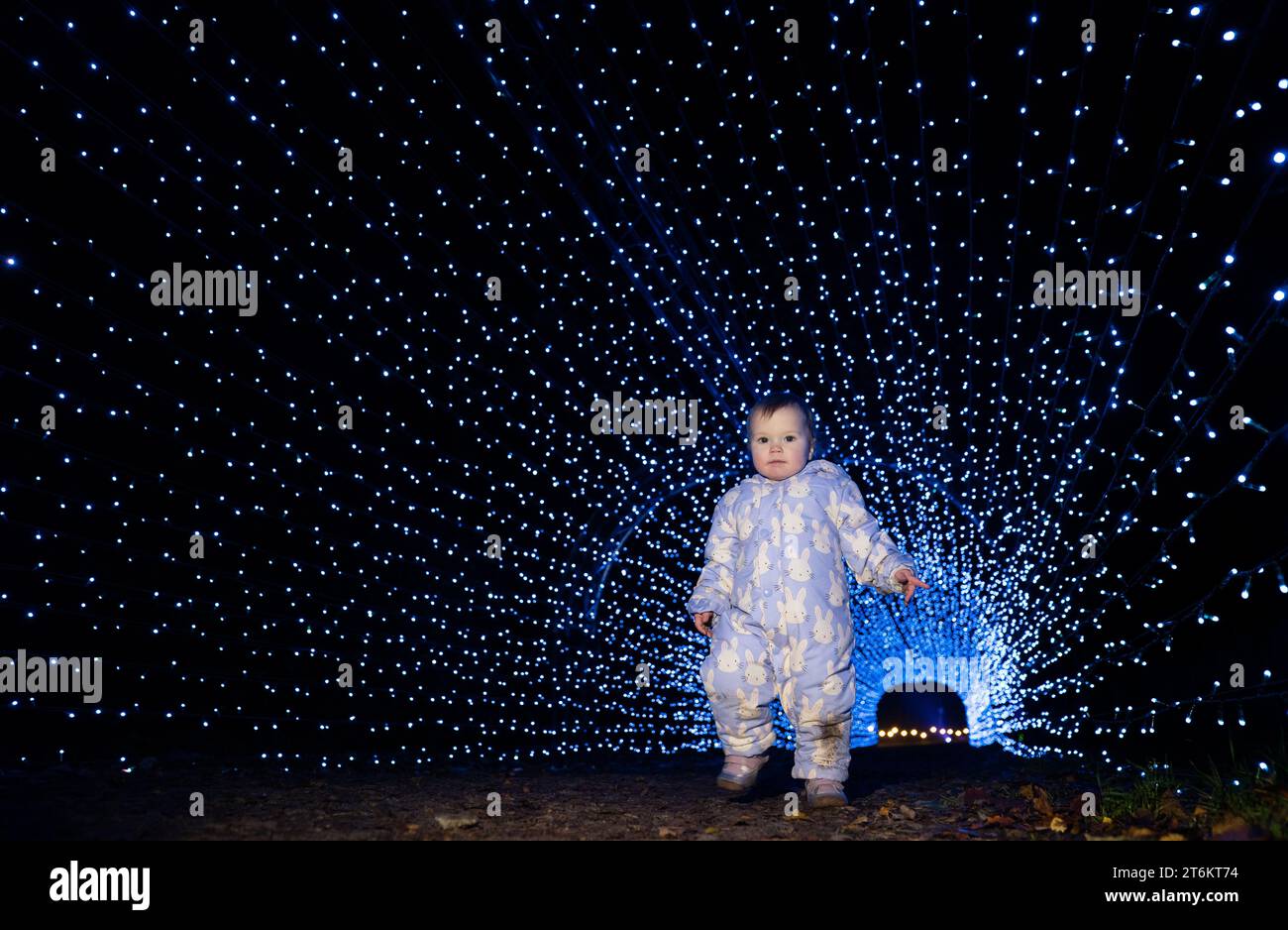 One-year-old Summer enjoys walking through a light installation during ...