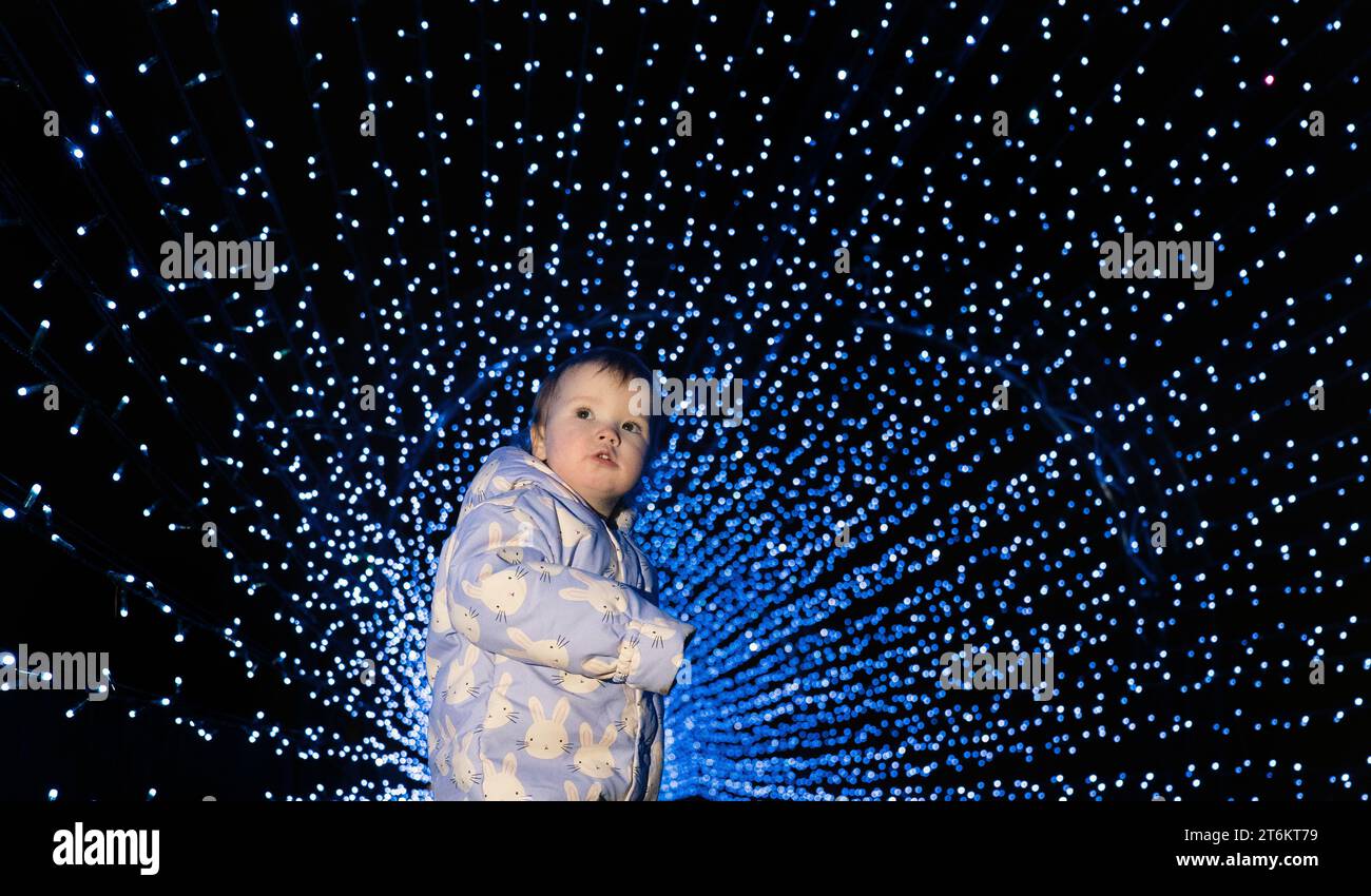 One-year-old Summer enjoys walking through a light installation during ...