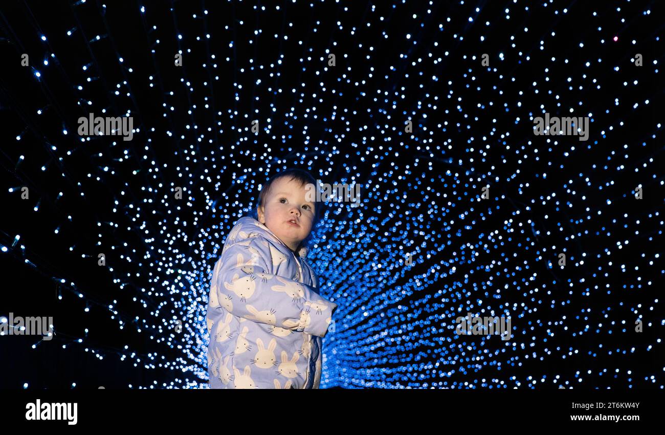 One-year-old Summer enjoys walking through a light installation during ...