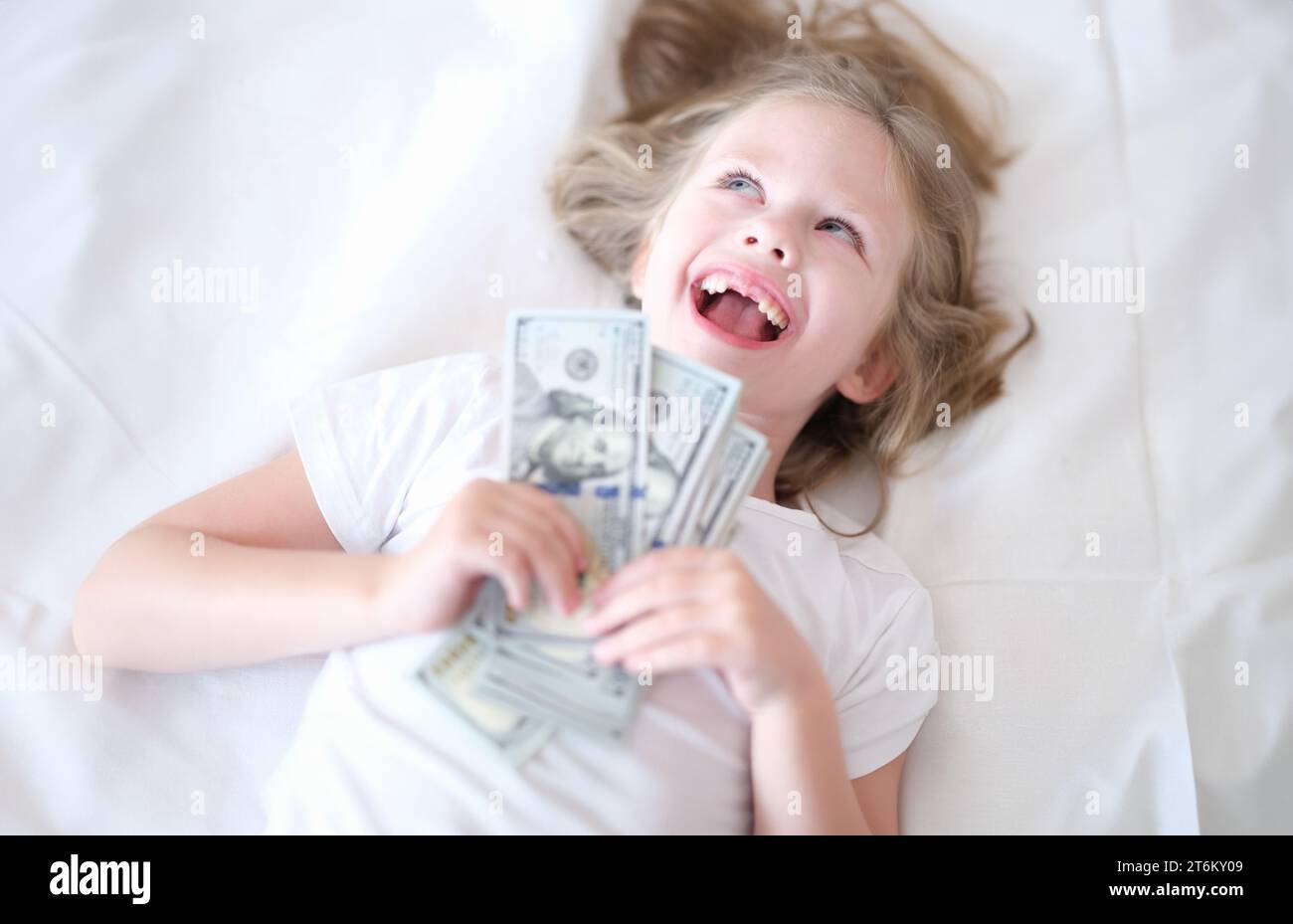 Little girl without front teeth holding money in her hands and smiling ...