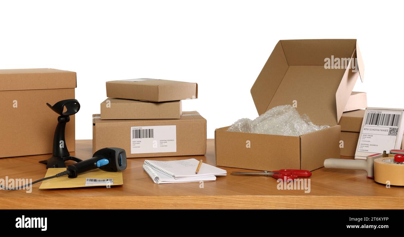 Parcels, barcode scanner and stationary on wooden table against white ...