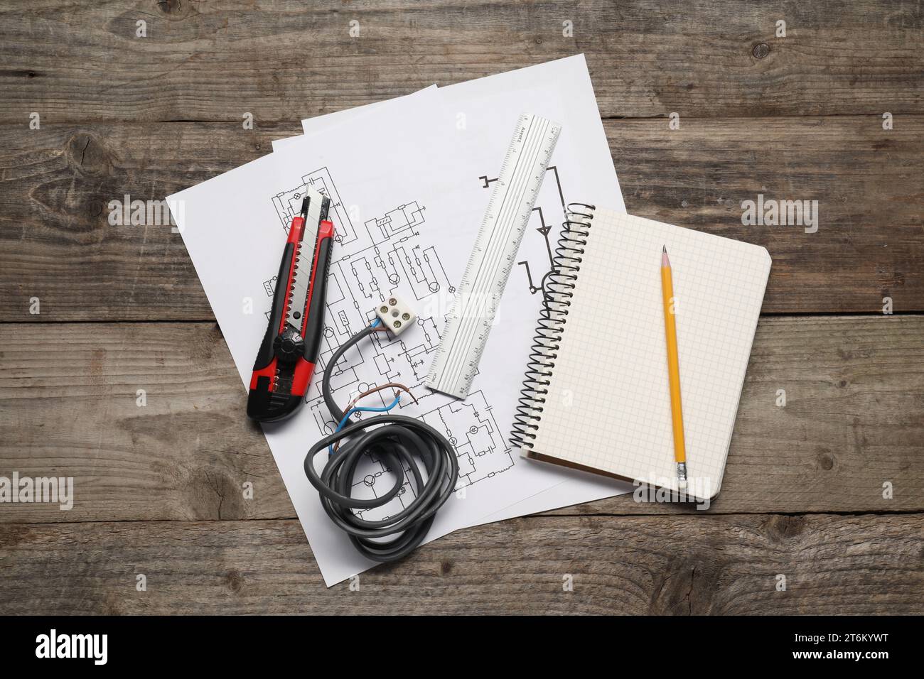 Wiring diagrams, wires, utility knife and office stationery on wooden ...