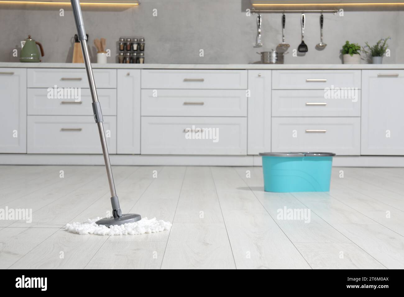 Mop and bucket on white parquet in kitchen. Cleaning floor Stock Photo ...