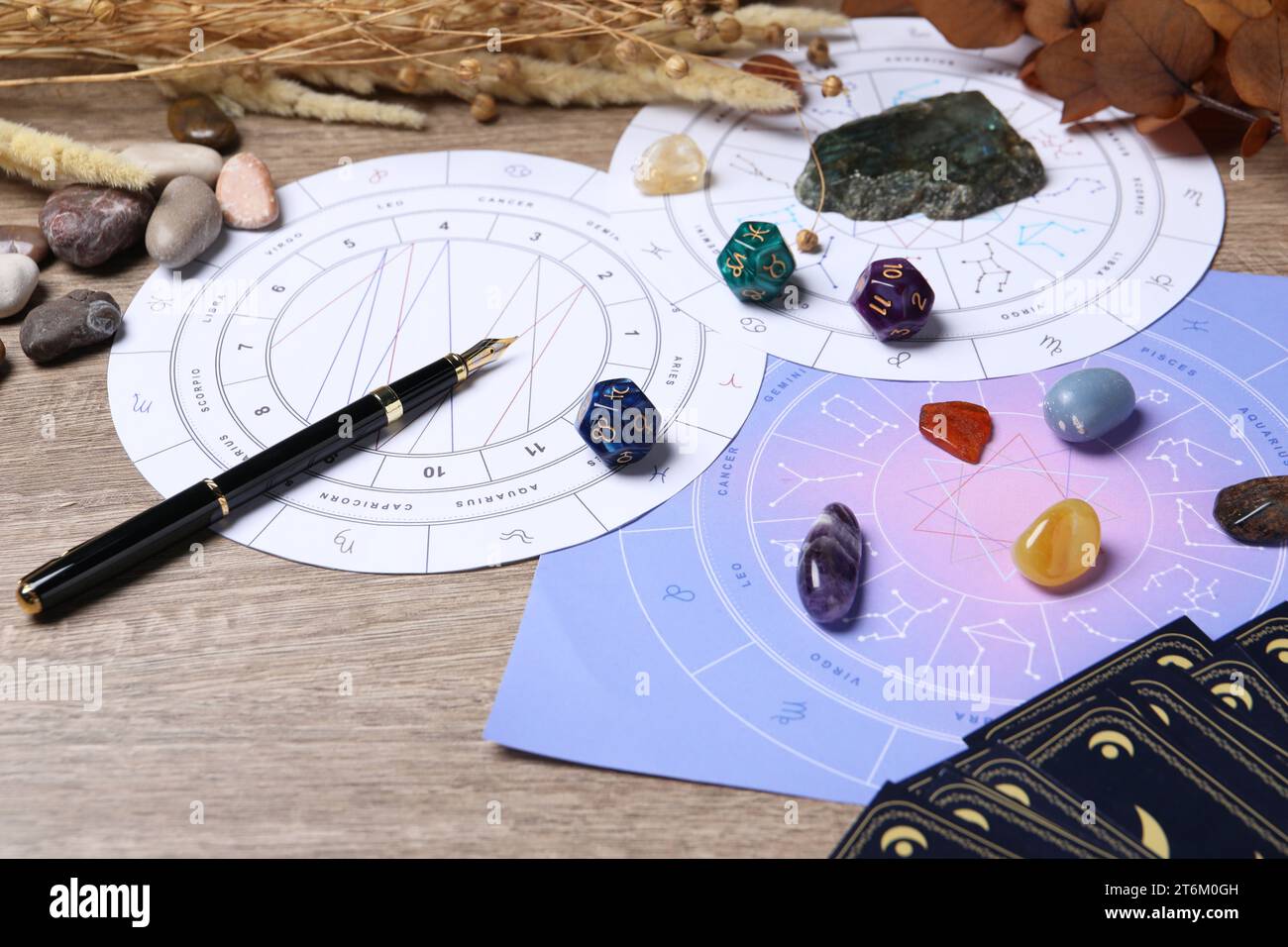 Zodiac wheels, natal chart, astrology dices and gemstones on wooden ...