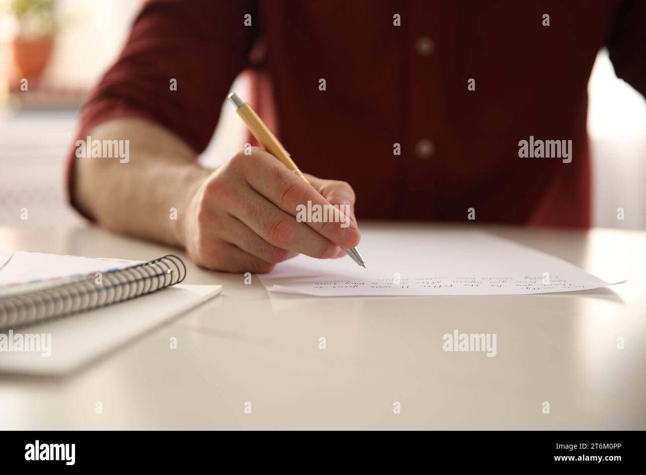 Man writing letter at white table in room, closeup Stock Photo - Alamy