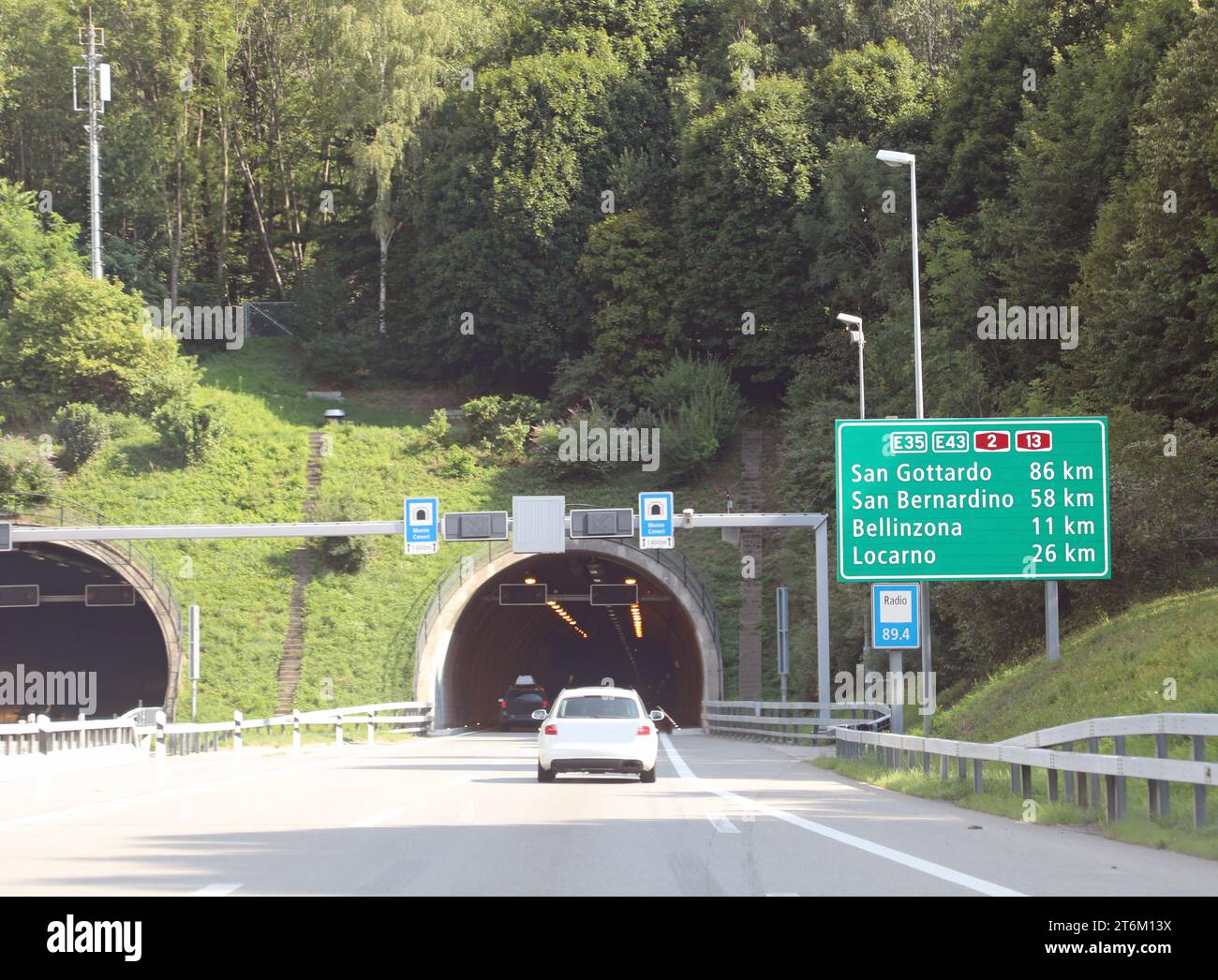 tunnel and road signs on the motorway with directions to many locations ...