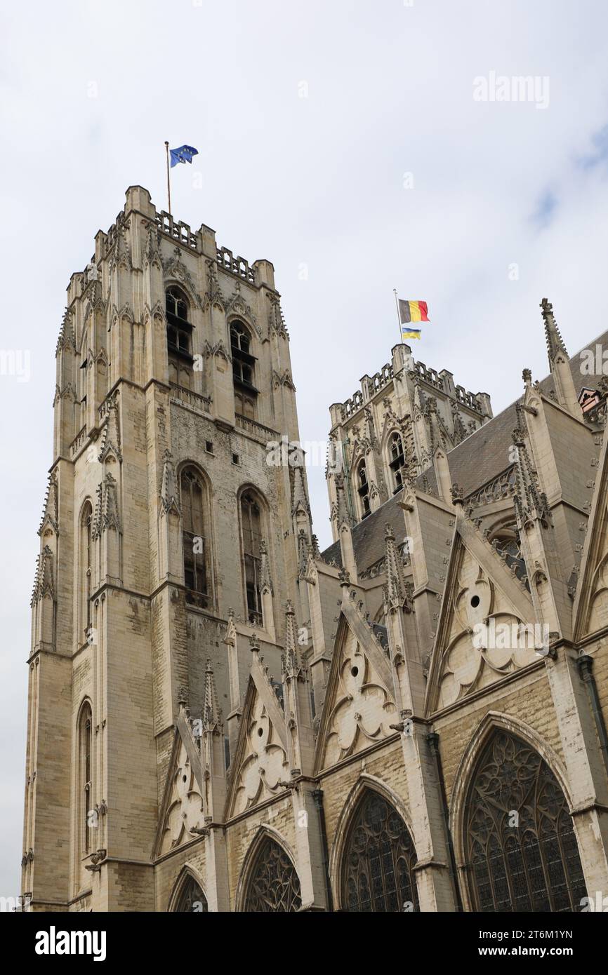 Cathedral of St Michael and St Gudula in Belgium with three flags of ...